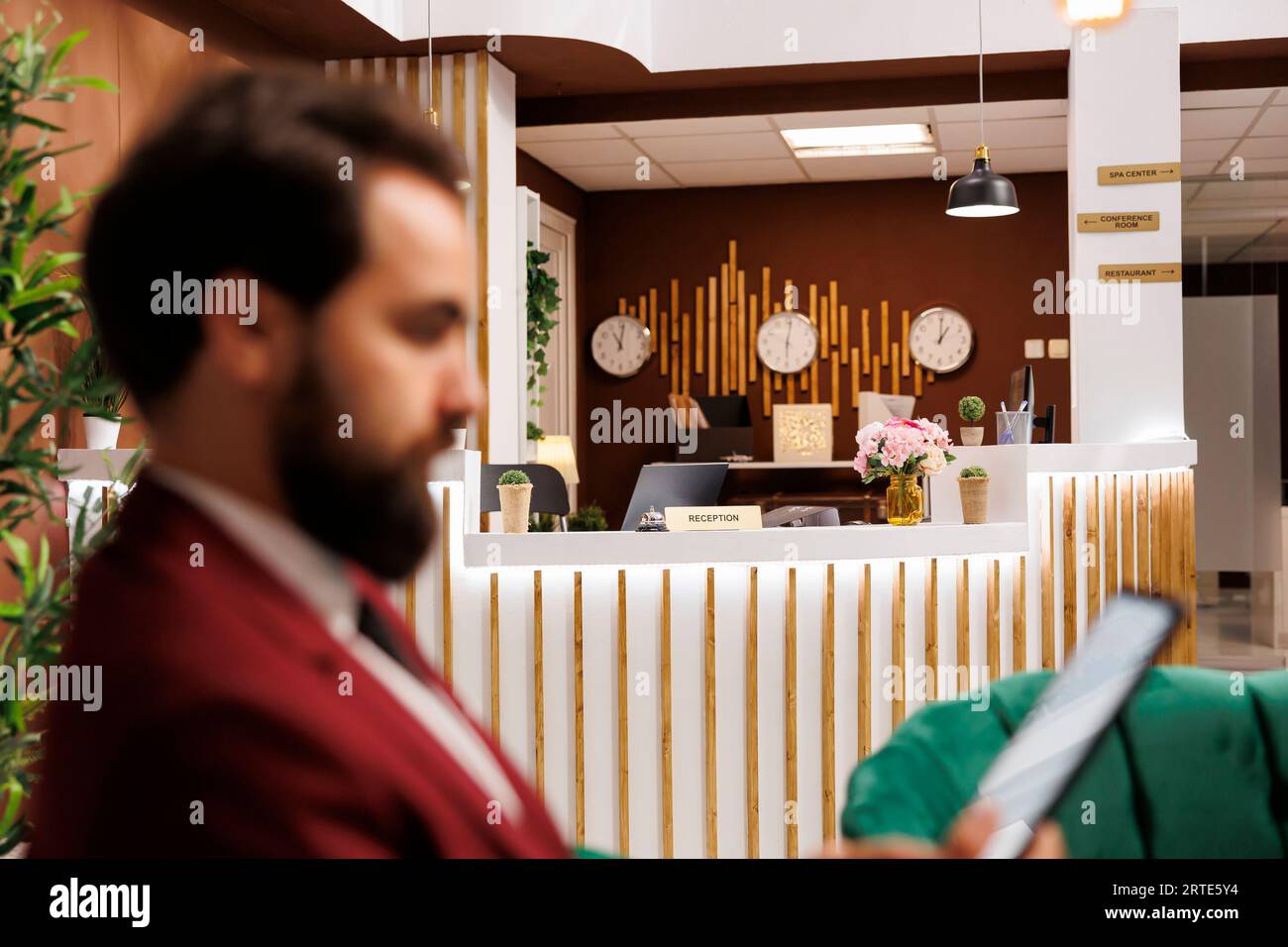 Hotel reception and lounge area with tourists waiting for check in ...