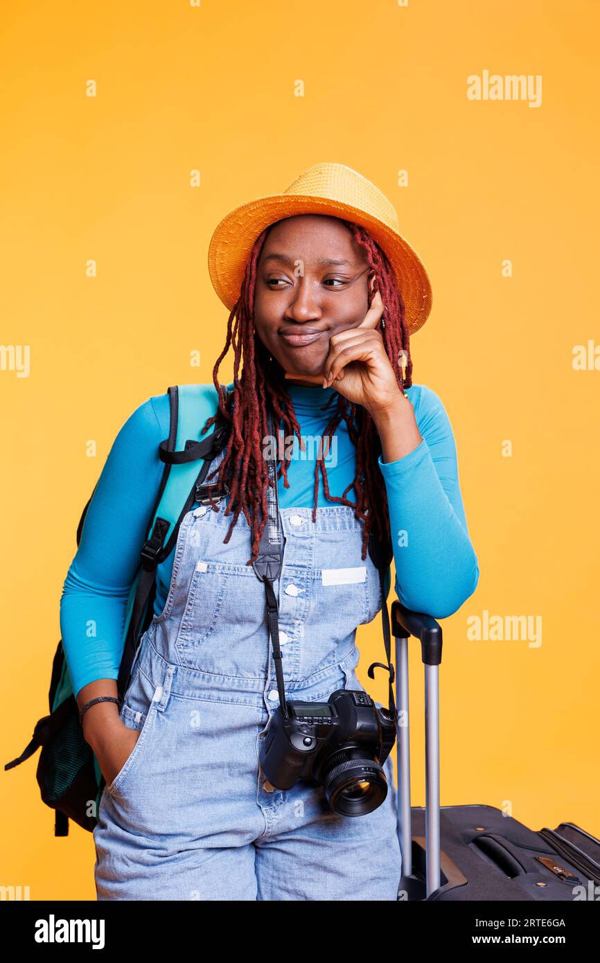 African american woman travelling abroad, posing in studio with dslr ...