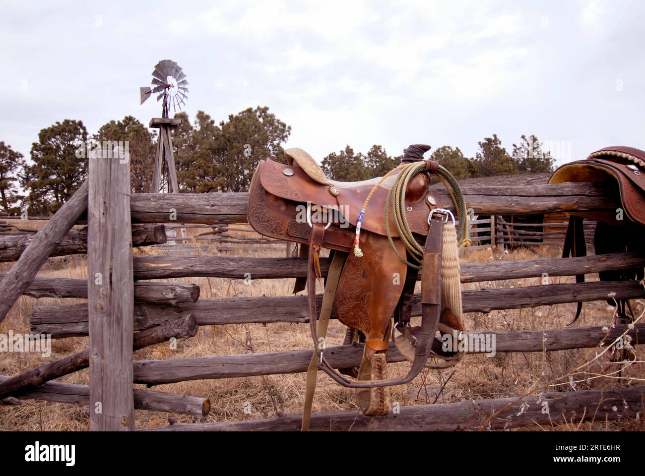 Saddles hanging on a wood rail fence, left by some ranchers in the ...