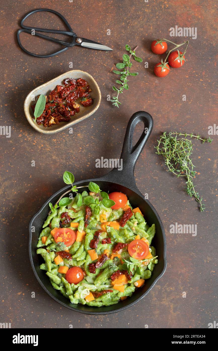 Green spaetzle with ricotta cream and tomatoes Stock Photo - Alamy