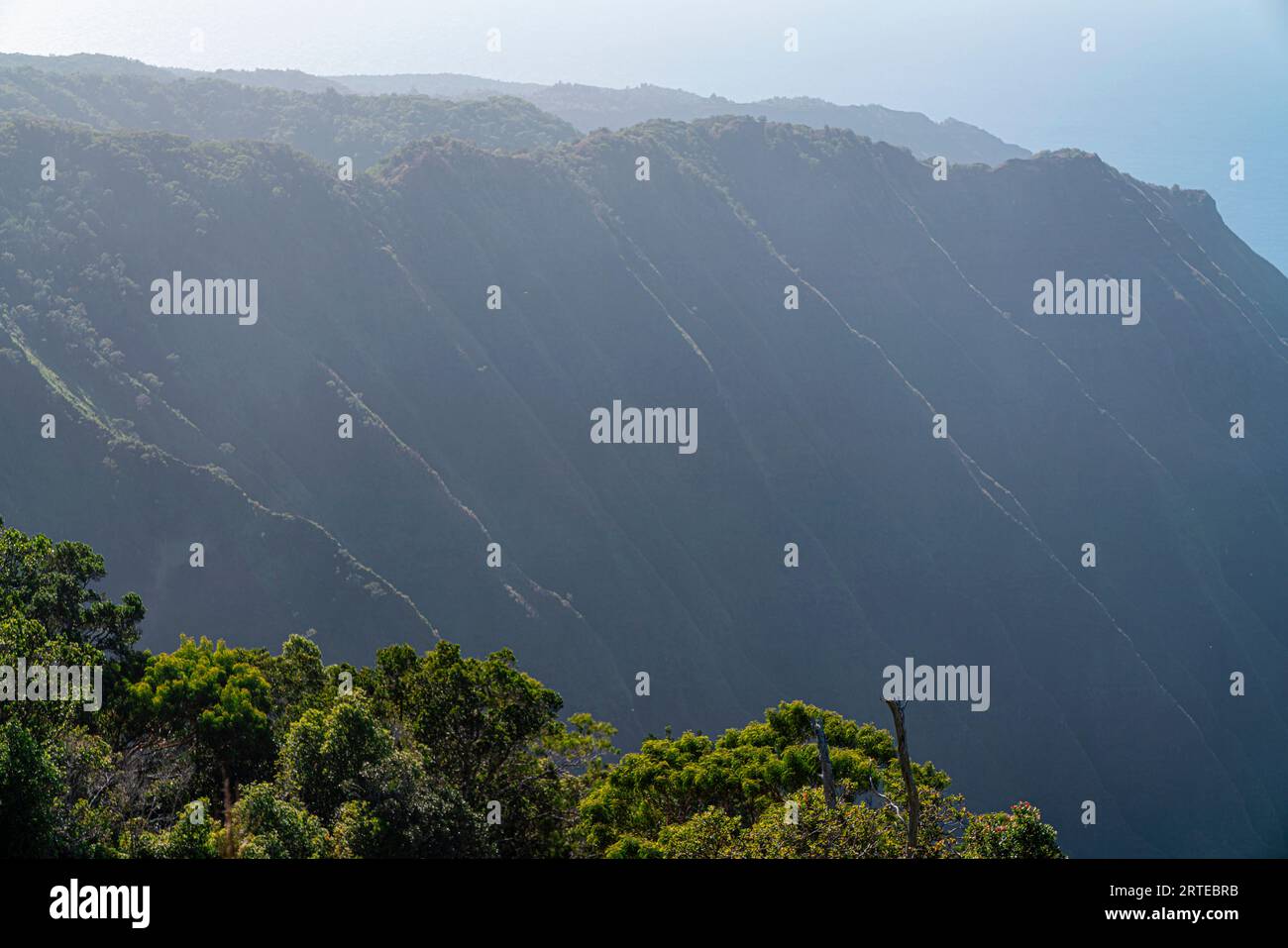Hazy view of the green covered mountain cliffs of the Napali Coast ...