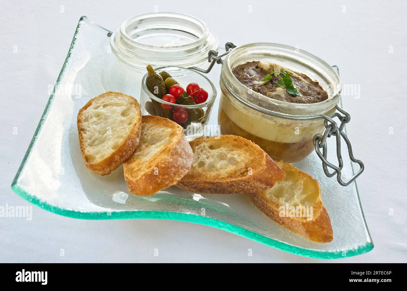 Boiled liver sausage, served with baguette, gherkins and tomatoes Stock ...