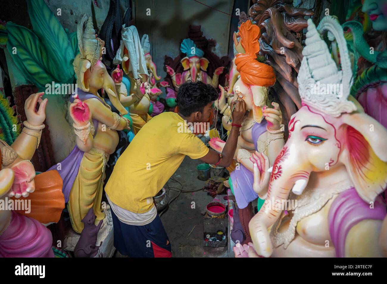 An artisan paints the eye of a clay idol of Hindu deity Lord Ganesha ...