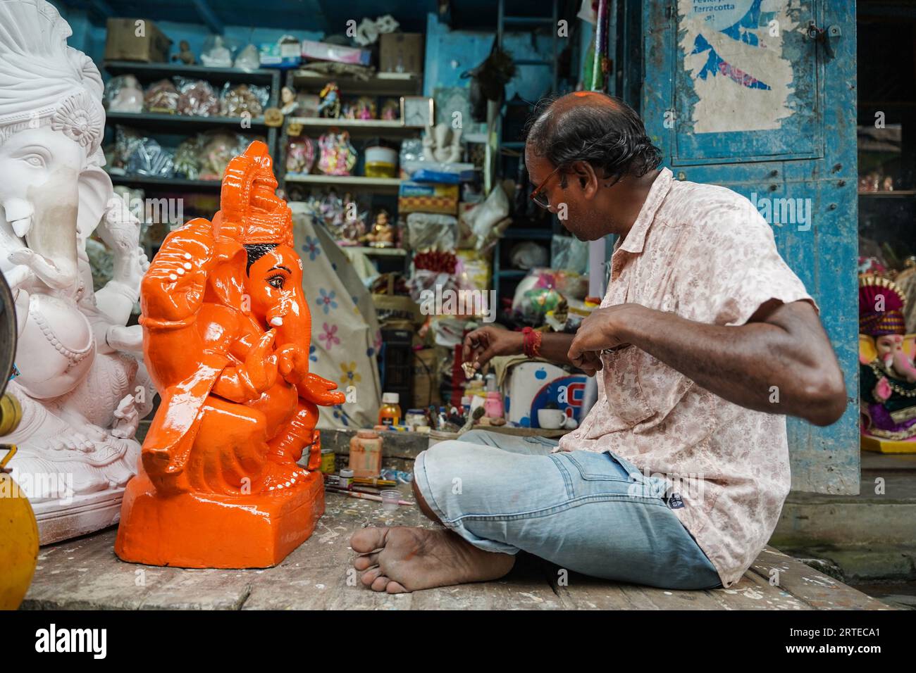 A clay artist gives finishing touches to an idol of Hindu deity Lord ...