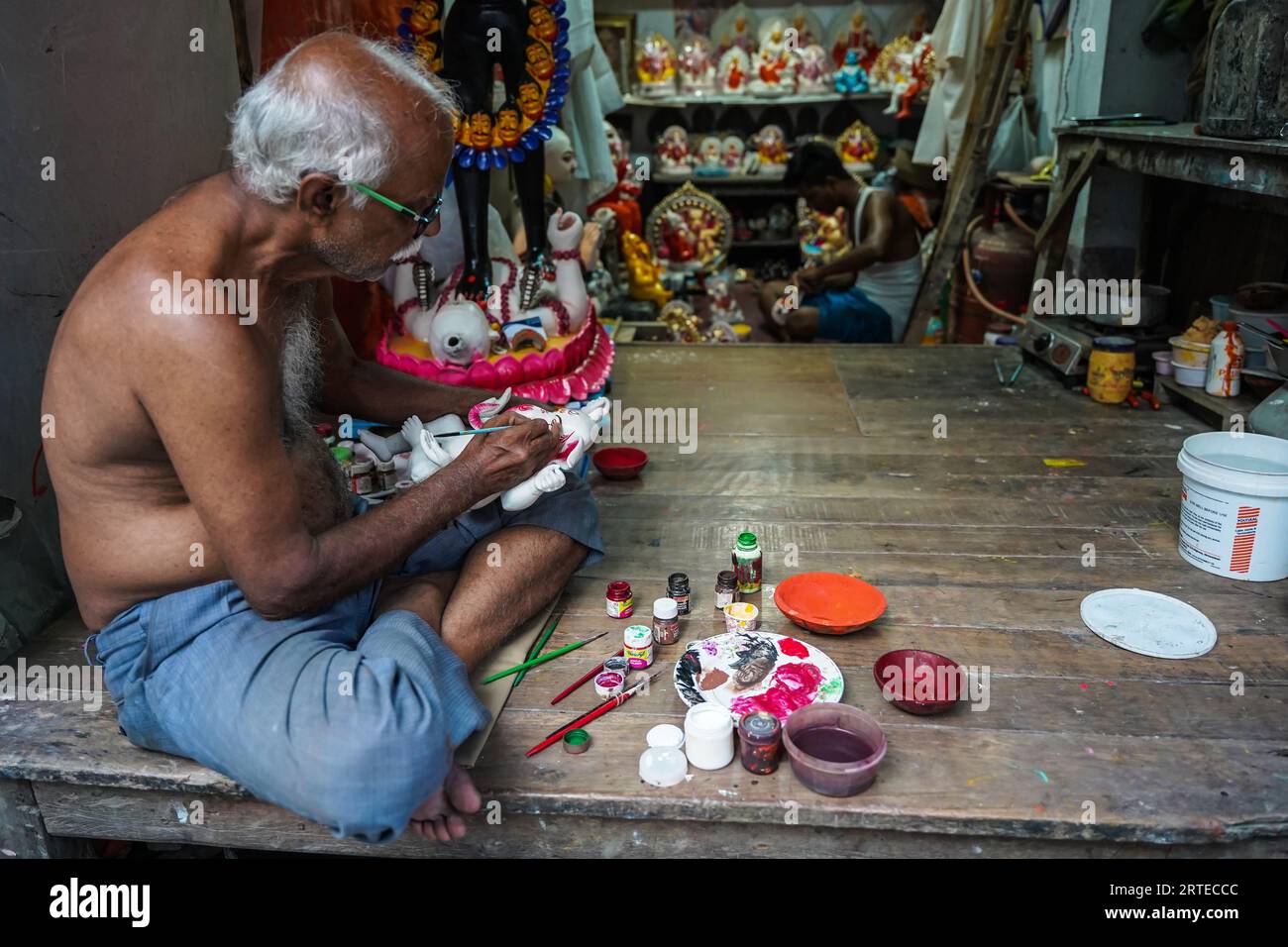 An elderly clay artisan paints a clay idol of Hindu deity Lord Ganesha ...