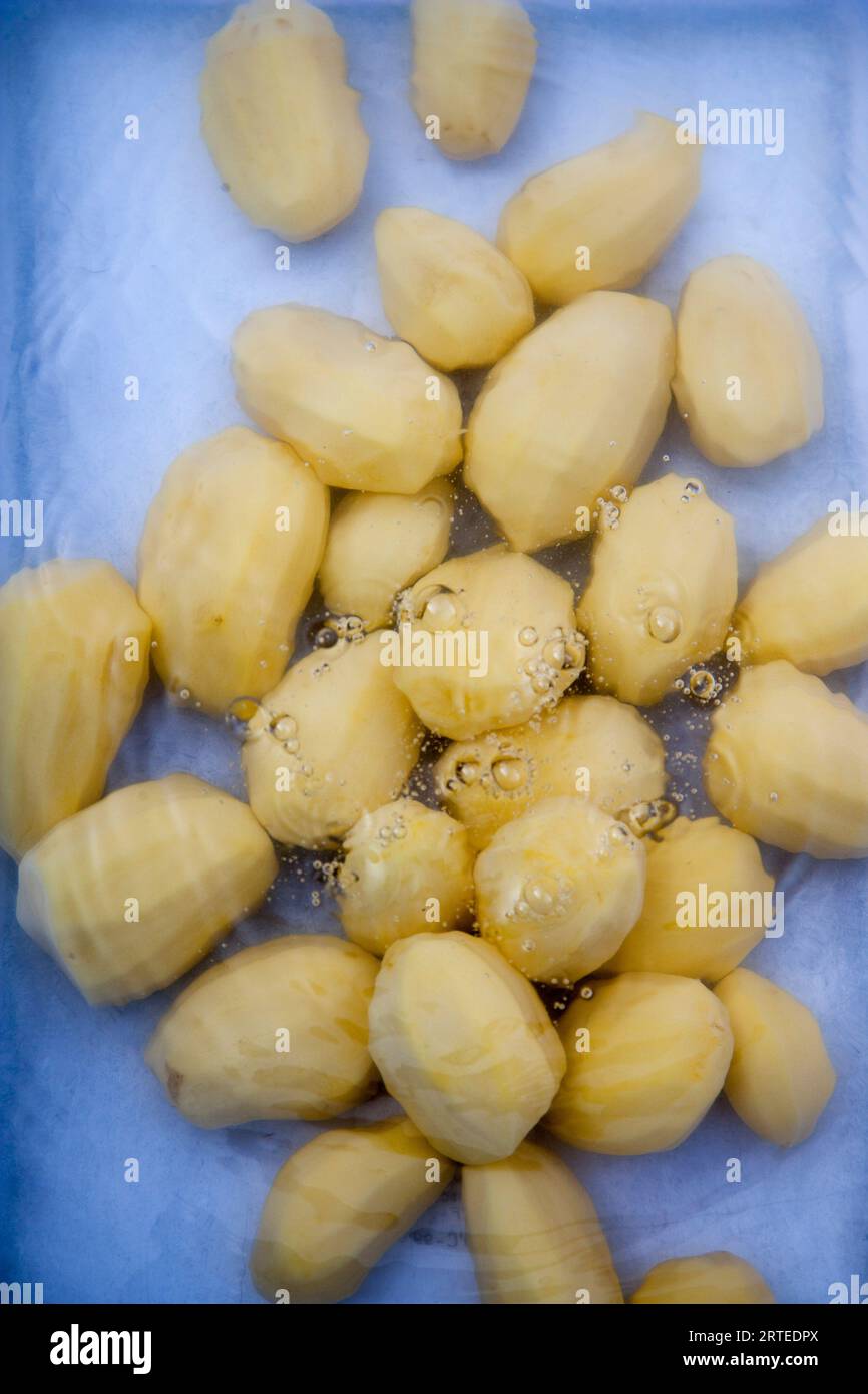 Peeled potatoes in water Stock Photo - Alamy