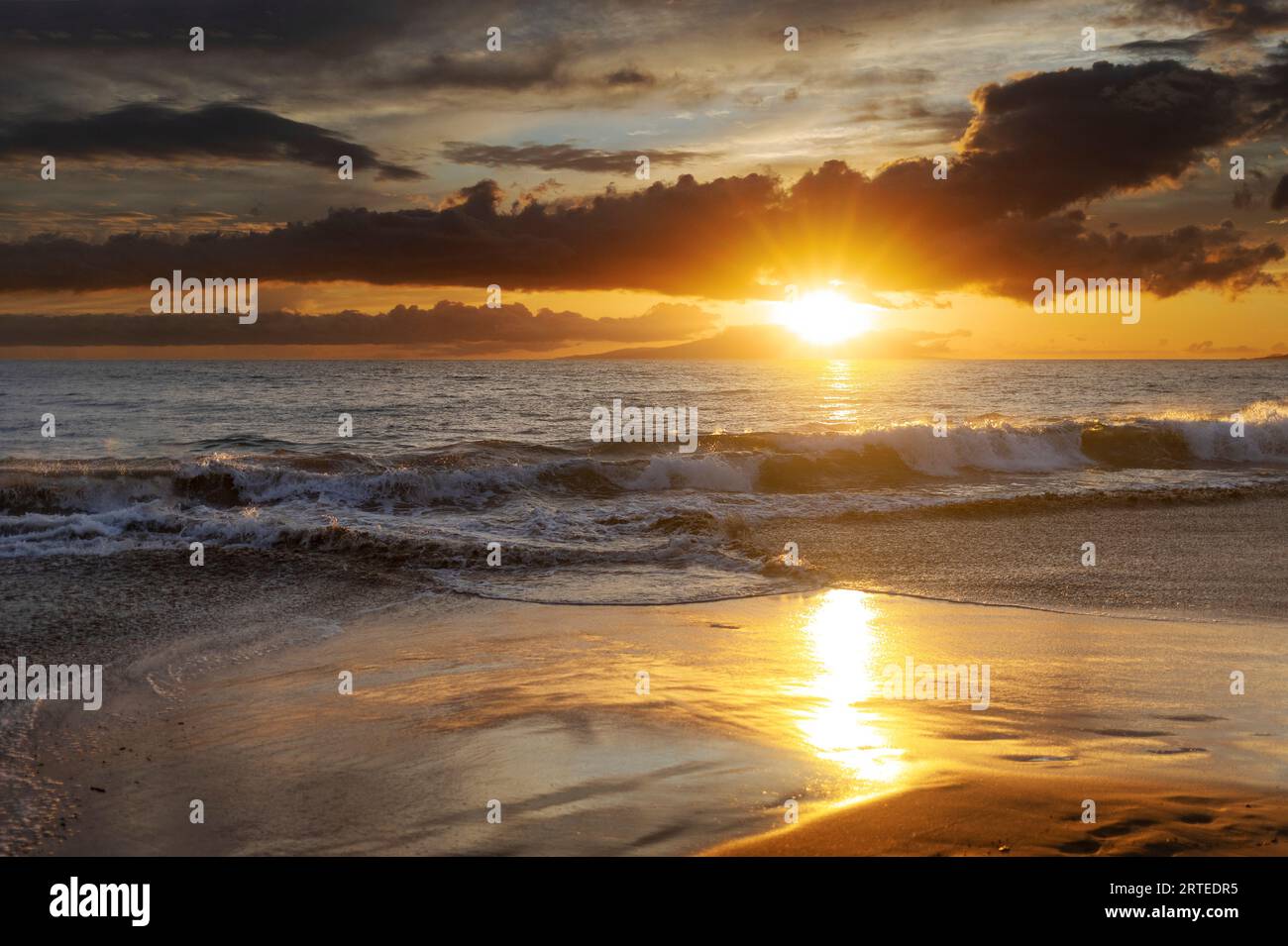 Ocean waves along the shoreline of Kamaole 2 Beach at twilight with a ...