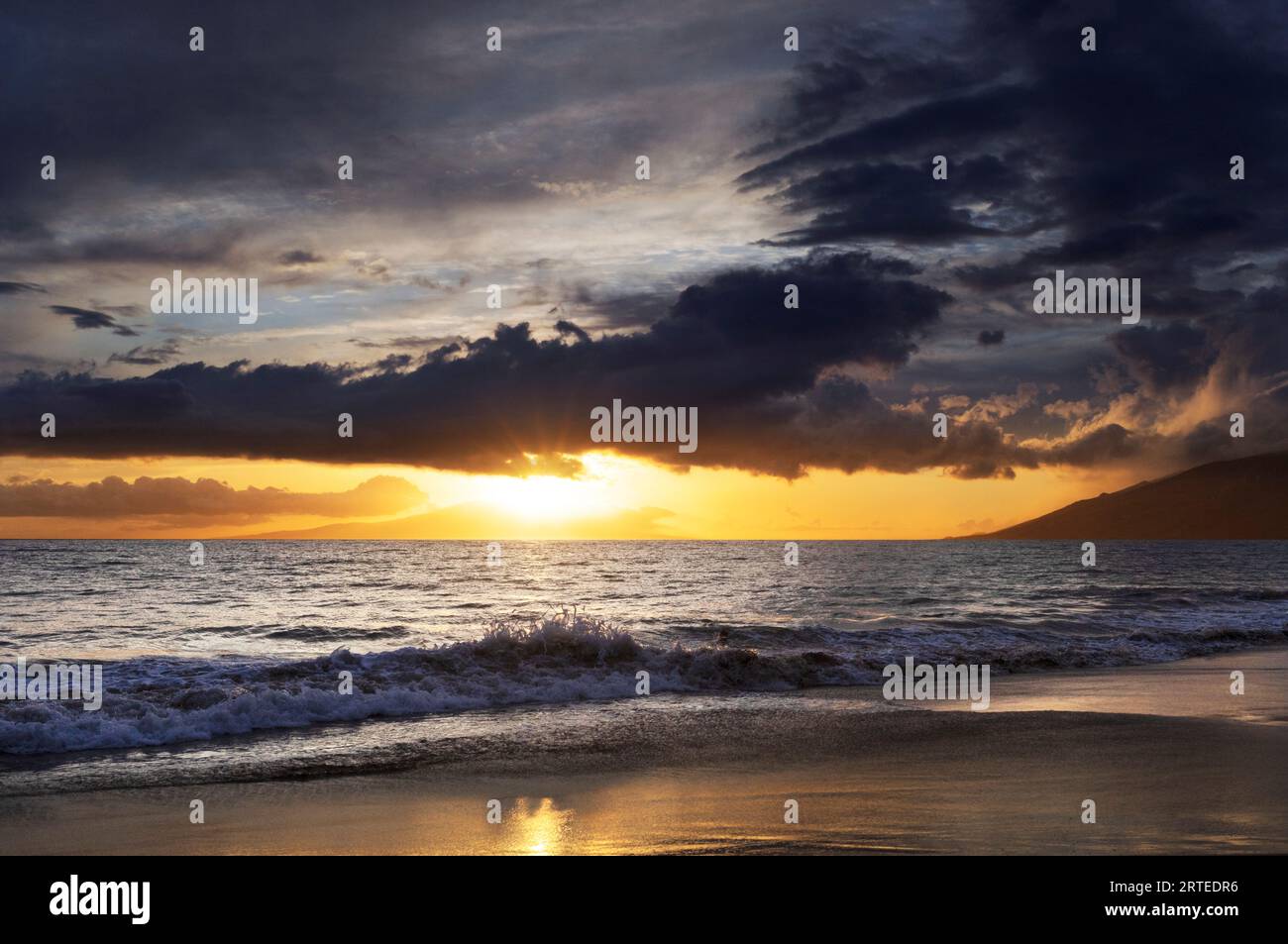 Ocean waves along the shoreline of Kamaole 2 Beach at twilight with a ...