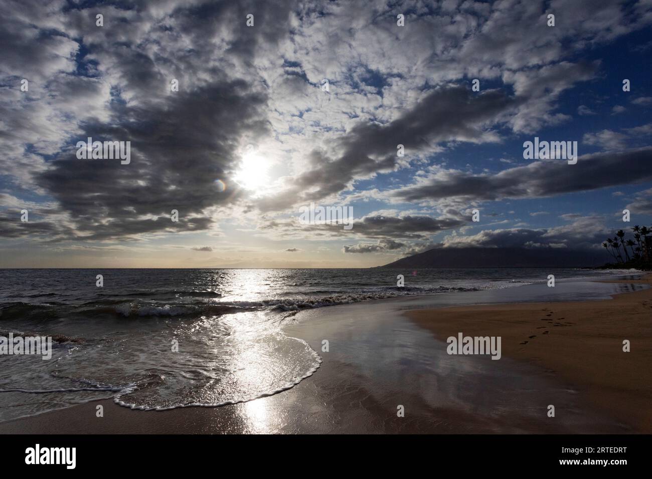 Ocean surf along the shoreline of Kamaole 2 Beach at twilight with ...