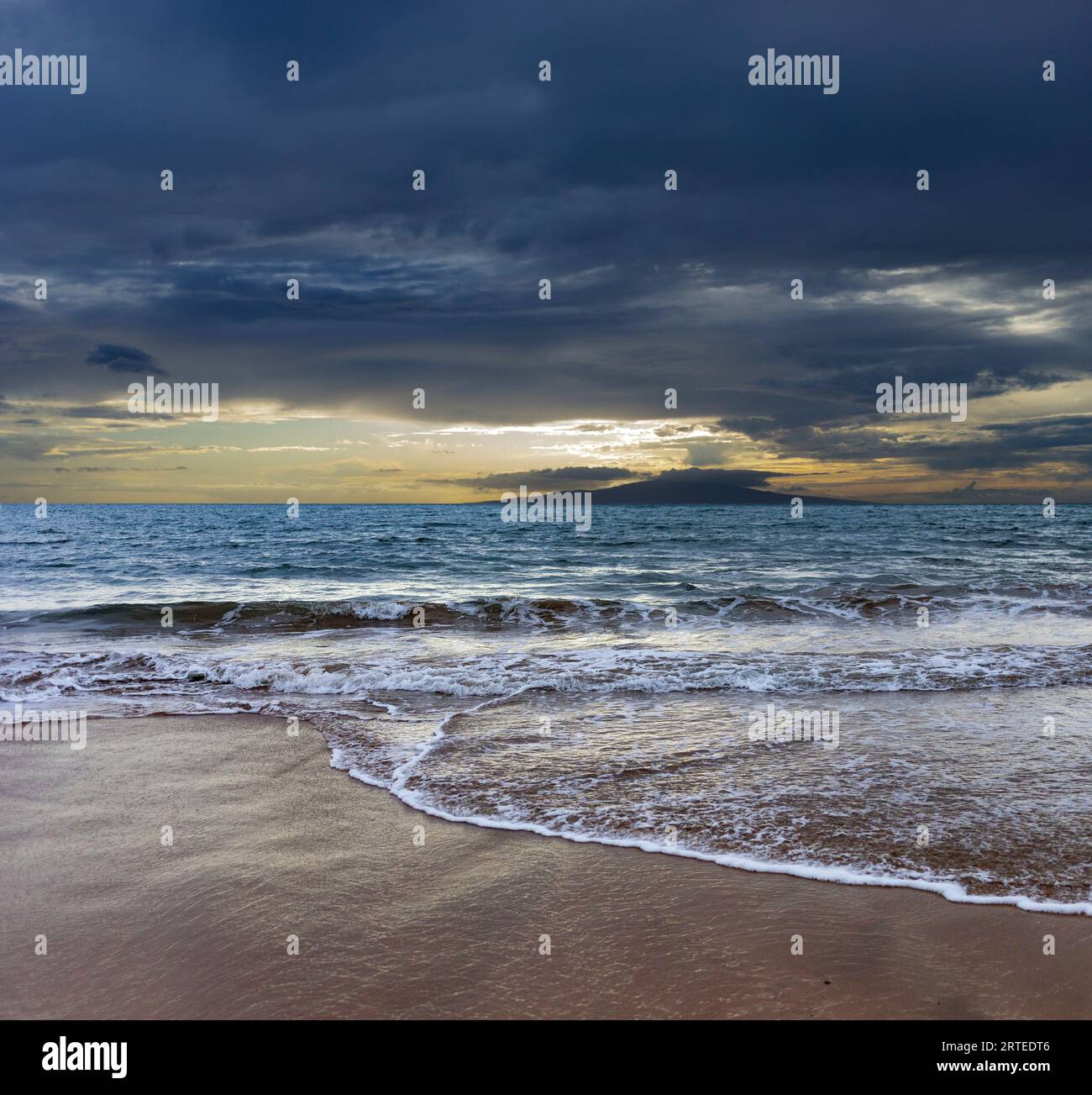 Ocean surf along the shoreline of Kamaole 2 Beach at twilight with ...