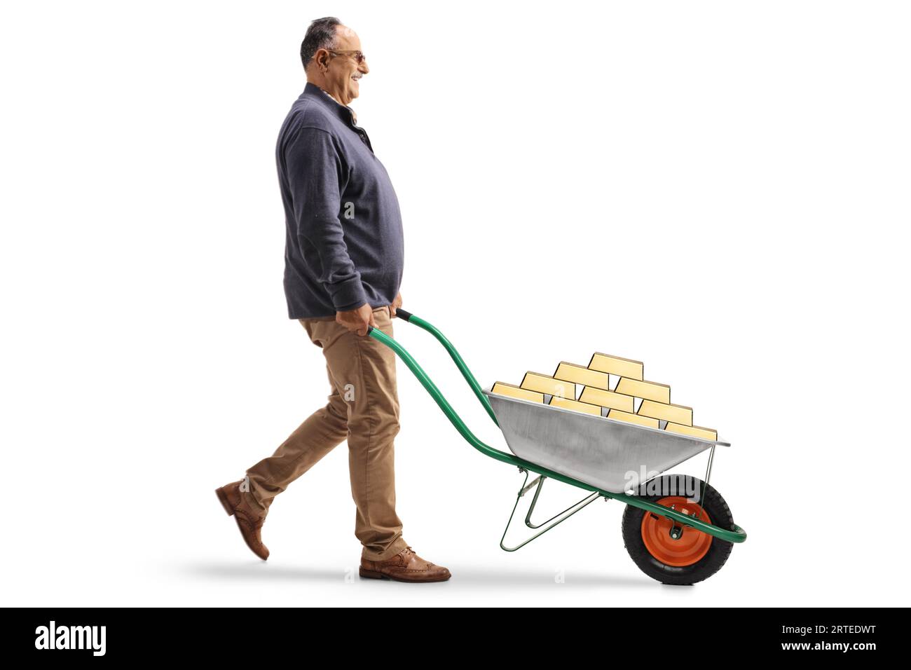 Full length profile shot of a mature man pushing a wheelbarrow with ...