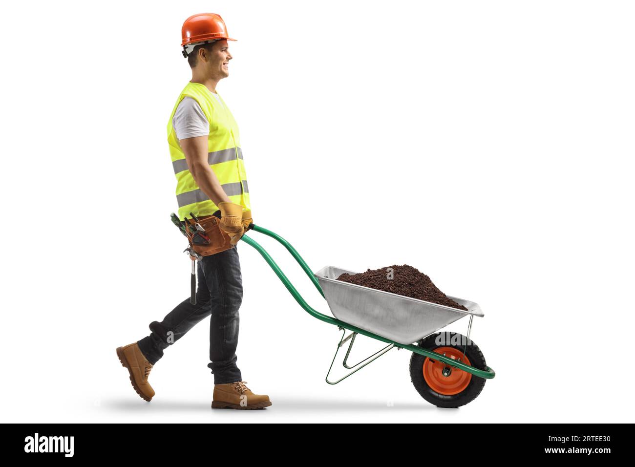 Full length profile shot of a construction worker pushing a wheelbarrow ...