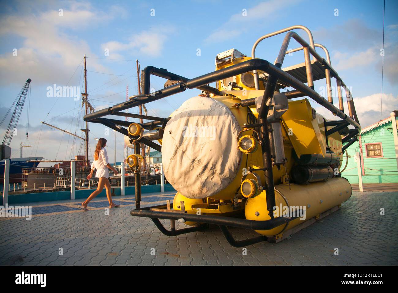 Young woman walking past an historical deep ocean, research submarine ...