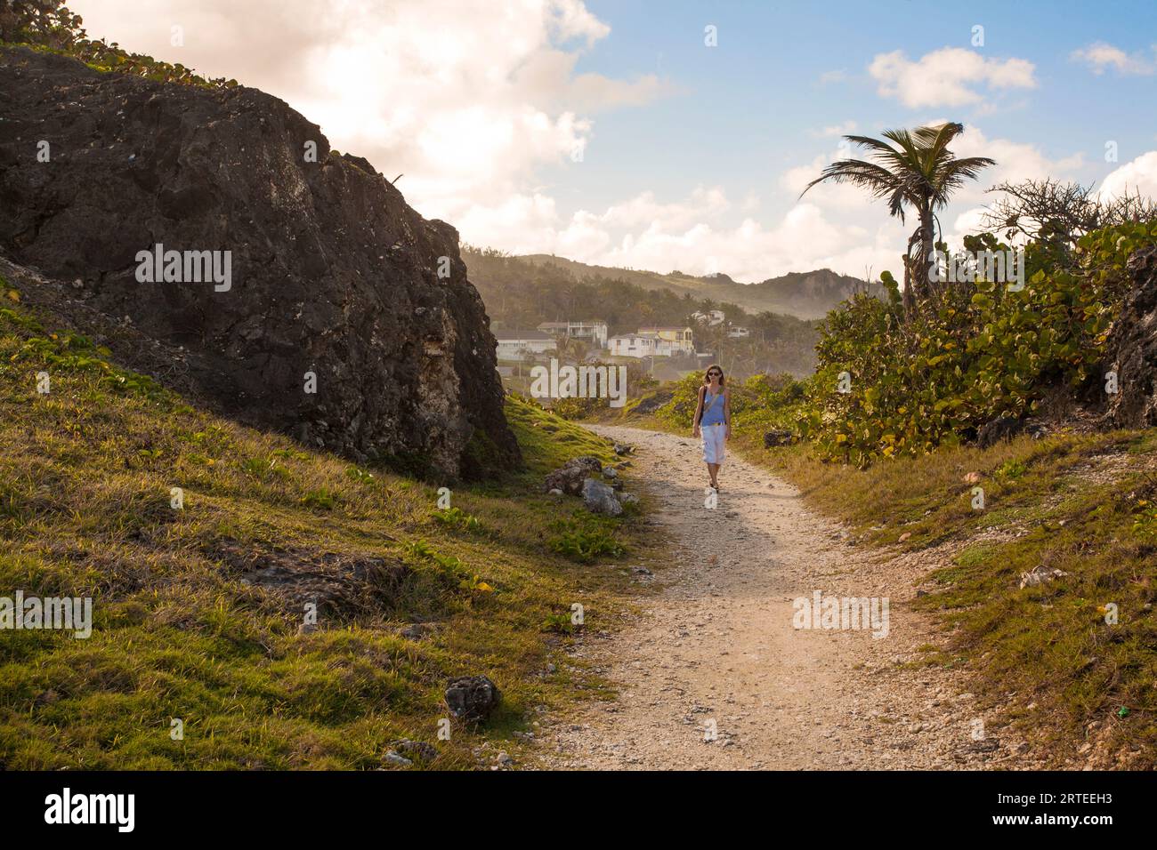 Scenic view of a woman walking on a seaside path at Bathsheba ...