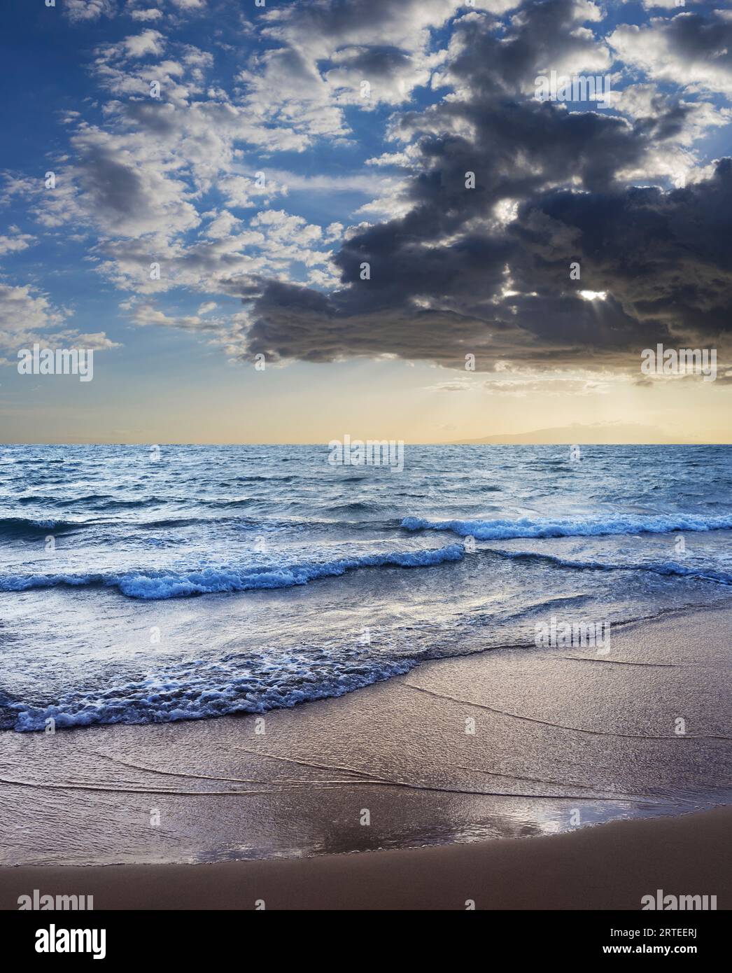 Breaking surf along the shoreline of Kamaole 2 Beach at twilight with a ...