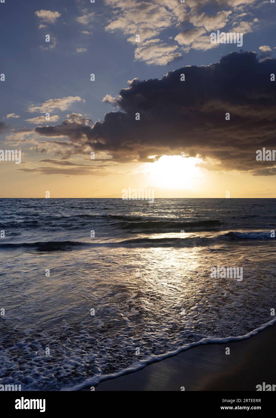 Breaking surf along the shoreline of Kamaole 2 Beach at twilight with ...