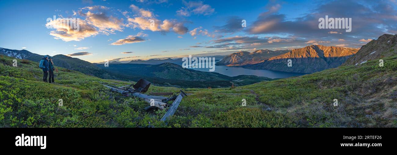Two women standing on a mountain top enjoying the view, while exploring ...