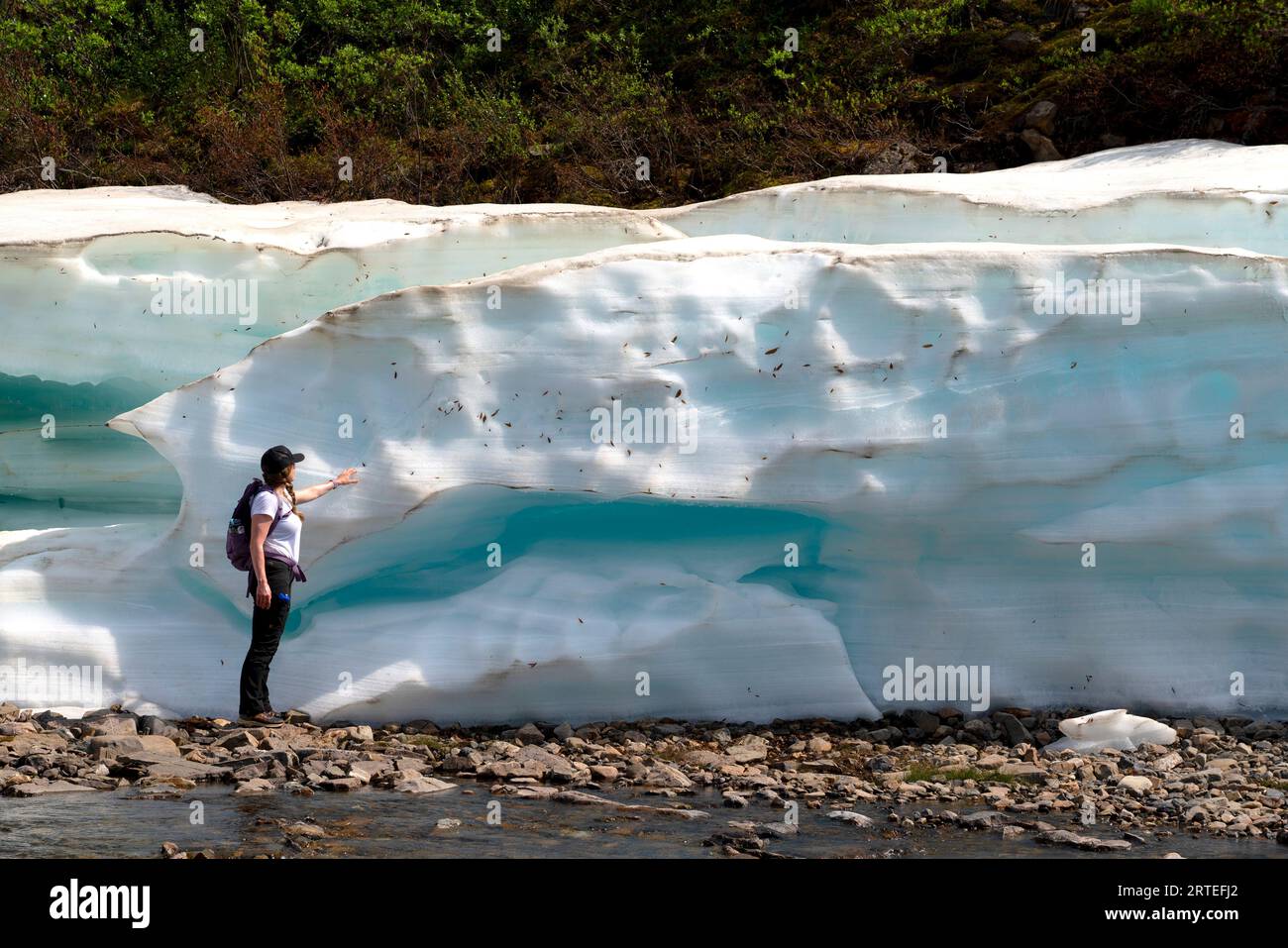 Close-up of woman exploring and touching the late season ice formation ...