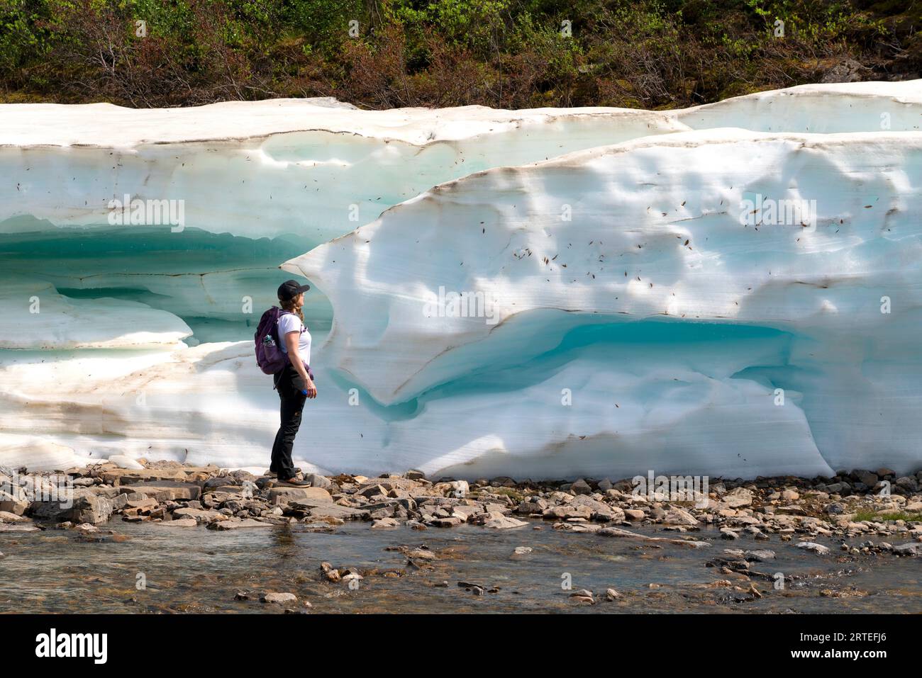 Close-up of a woman exploring and standing next to the late season ice ...