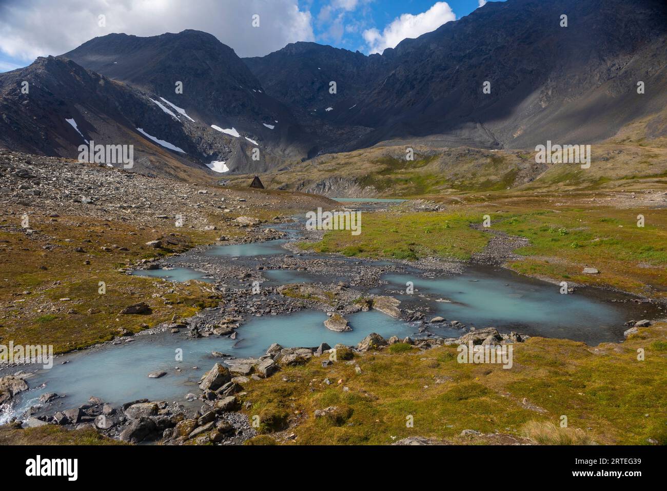 A milky, glacier fed Crow Creek, flows through the tundra away from the ...