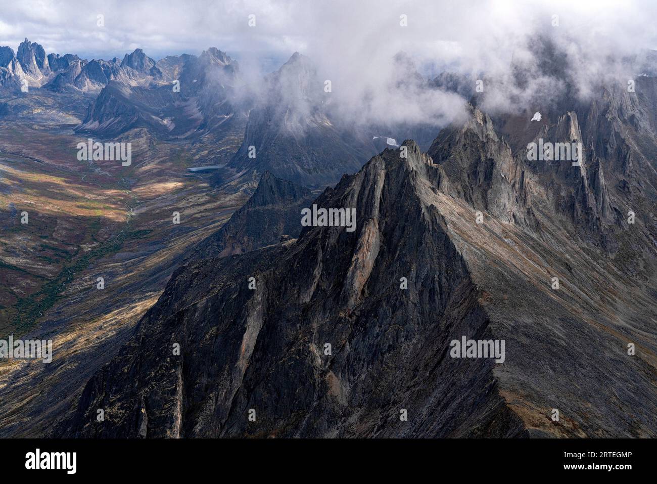Aerial view of rugged mountain peaks and a valley with tundra in autumn ...