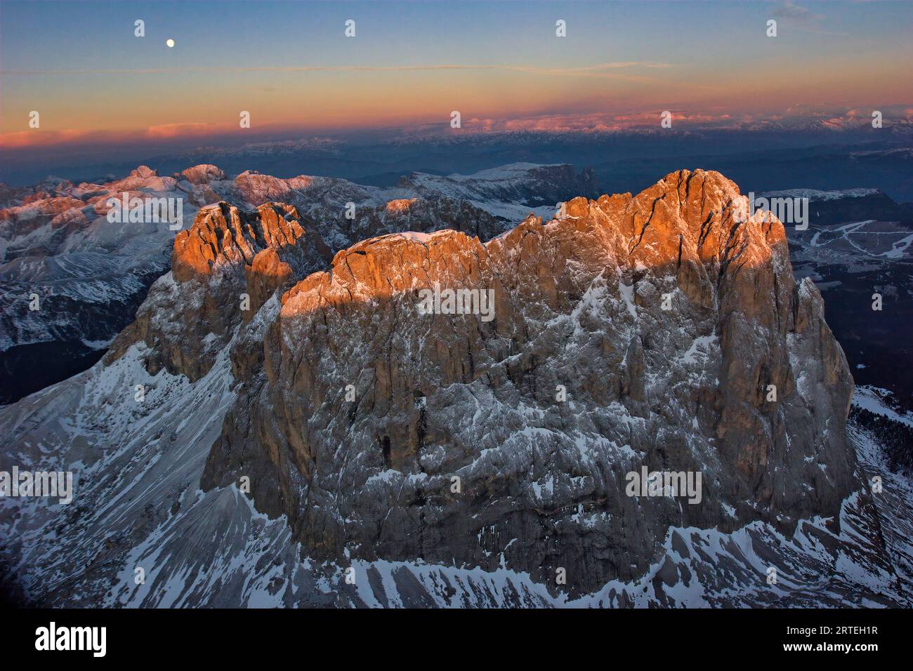 Aerial view of the Dolomite Mountains at sunrise and a visible moon ...