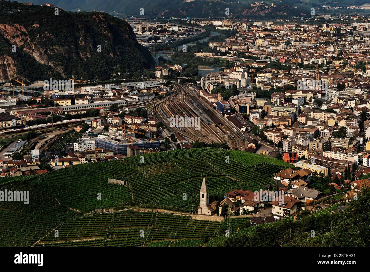 Bird's eye-view of a vineyard, church and the city of Bolzano, Italy ...