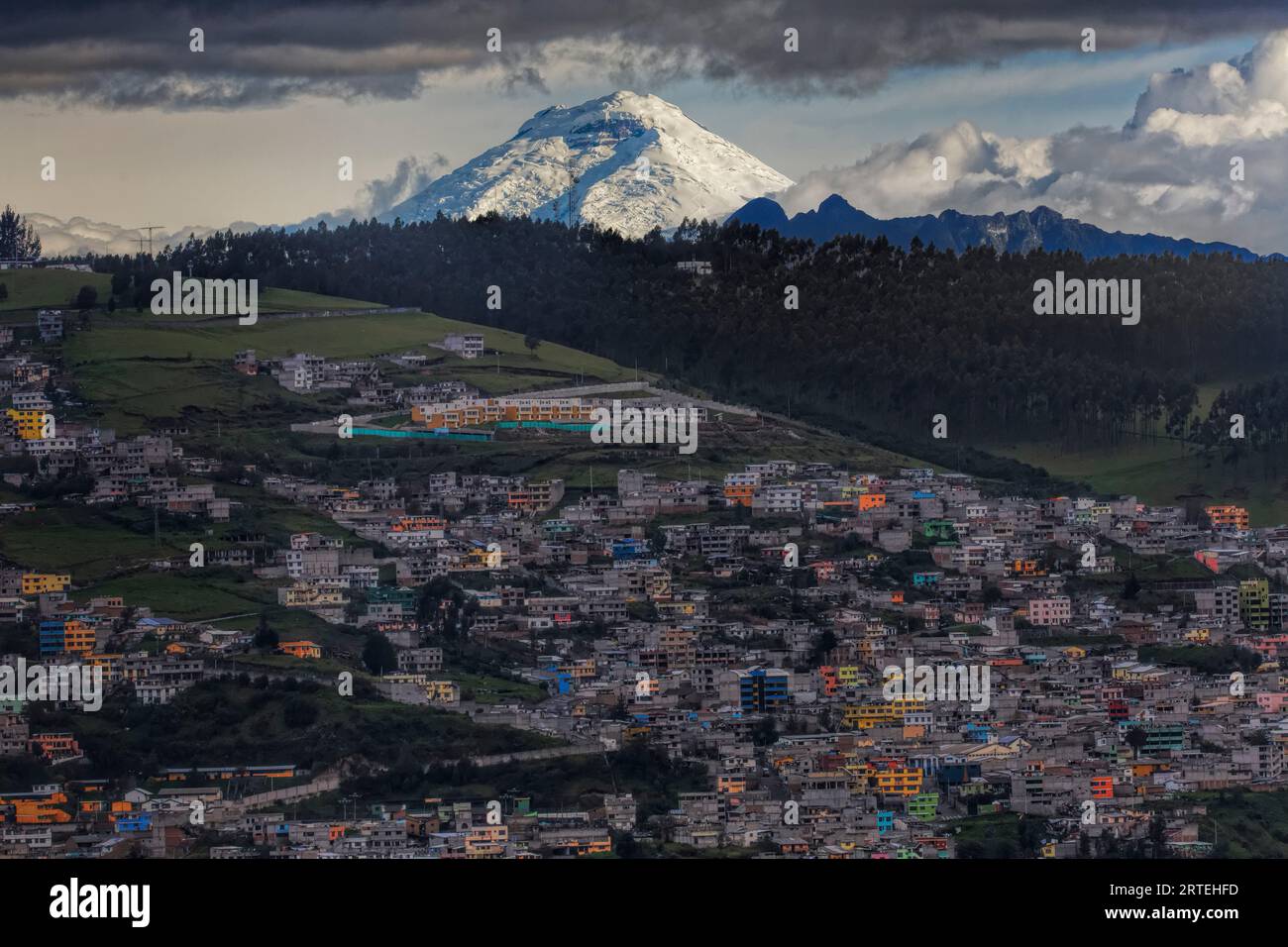 Cotopaxi volcano looms above the hillside town of Quito; Quito, Ecuador ...