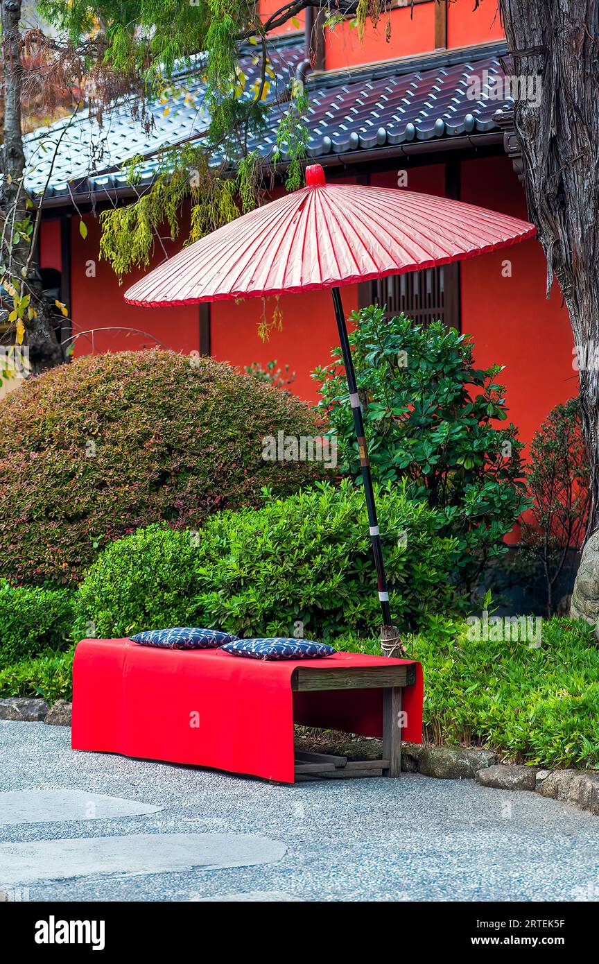 Red umbrella over a bench outside a temple; Tokyo, Japan Stock Photo ...