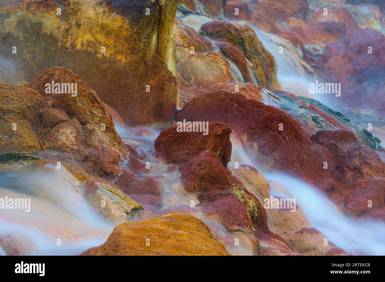 Hot water from geysers pours down rocks in the Valley of Geysers ...