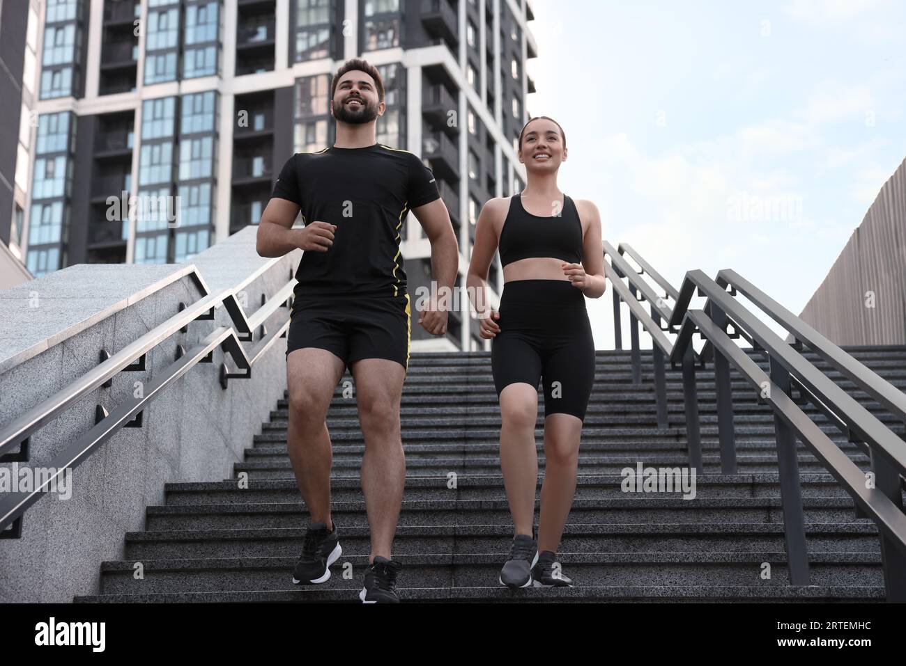Healthy lifestyle. Happy couple running on steps outdoors, low angle ...
