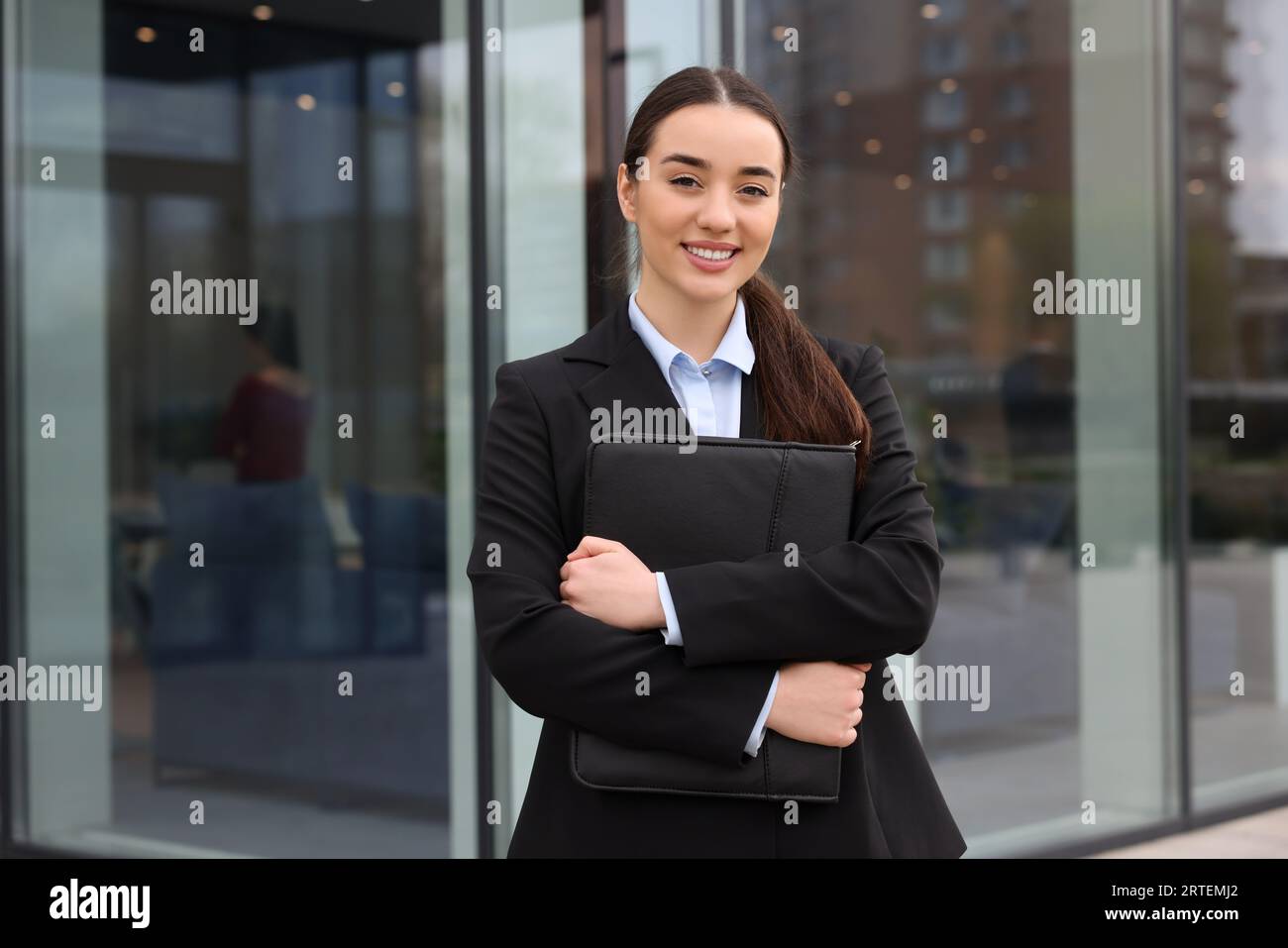 Female real estate agent with leather portfolio outdoors Stock Photo ...