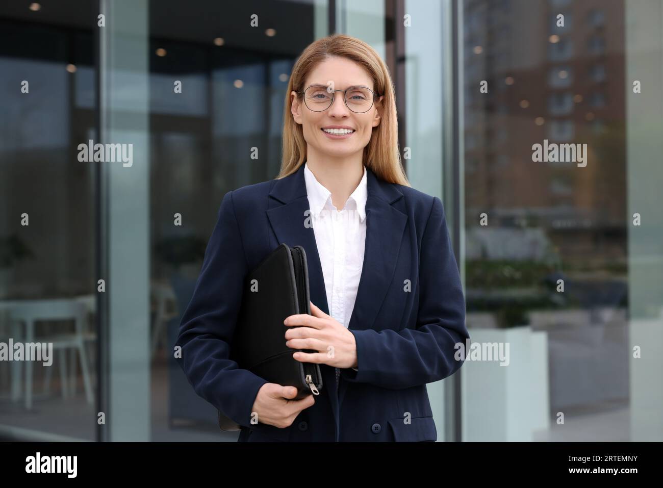 Female real estate agent with leather portfolio outdoors Stock Photo ...