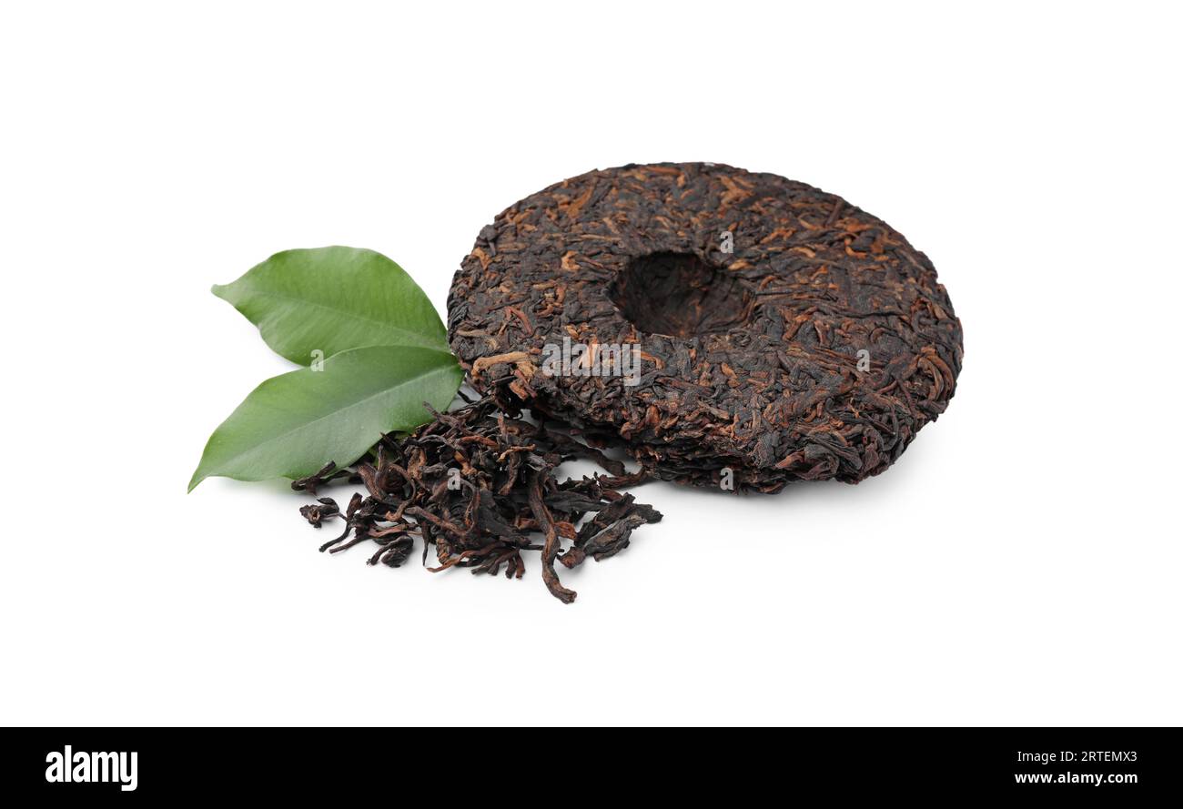 Broken disc shaped traditional Chinese pu-erh tea and fresh leaves ...