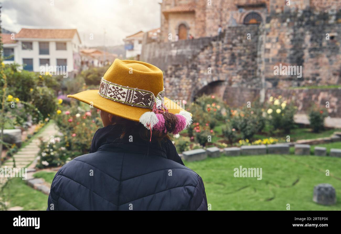 Exploring Qorikancha Inner Gardens. Beautiful Tourist with Hat in Cusco ...