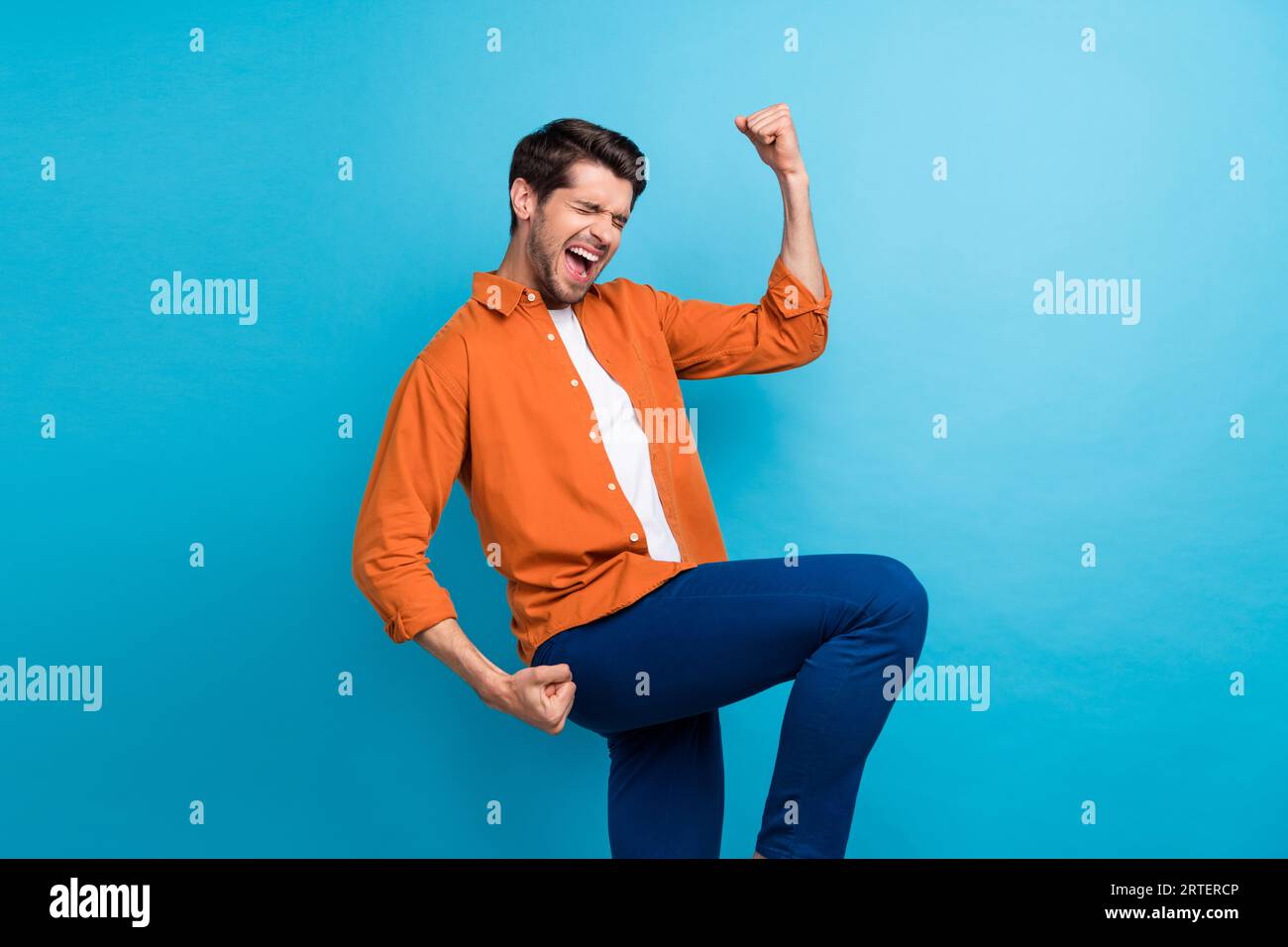Photo of lucky impressed man dressed orange shirt shouting yeah rising ...