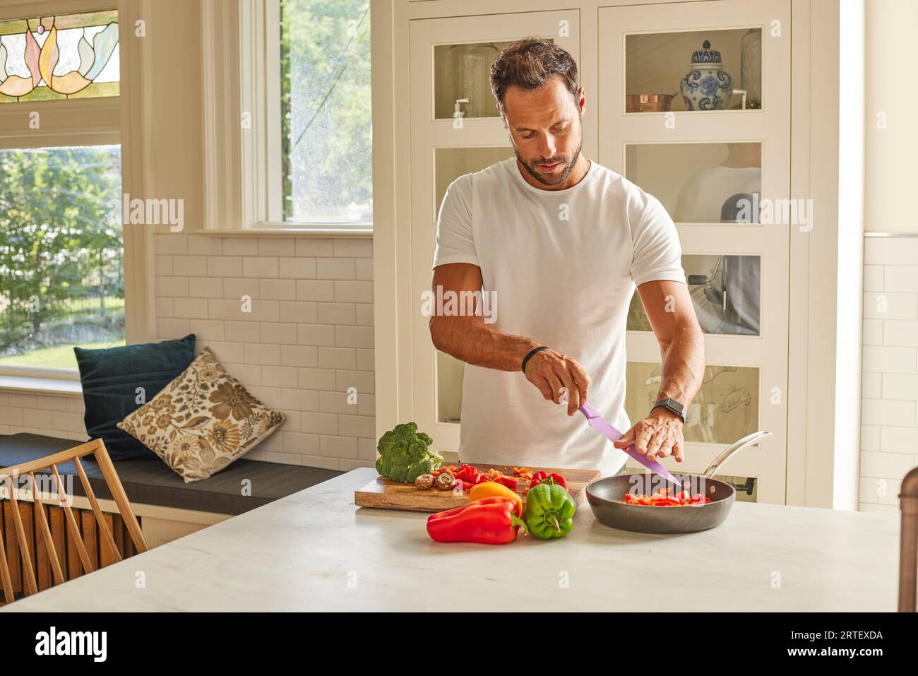 Man cutting vegetables in kitchen Stock Photo - Alamy