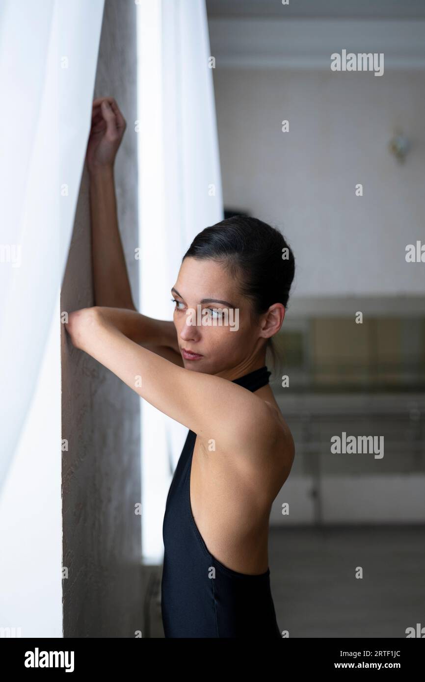Ballerina leaning on wall and looking through window Stock Photo - Alamy
