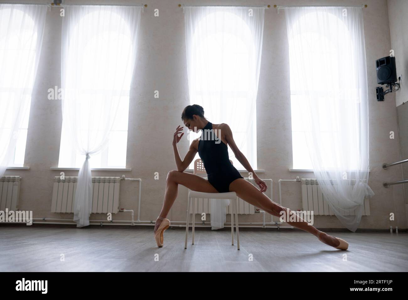 Ballerina practicing on chair at dance studio Stock Photo - Alamy