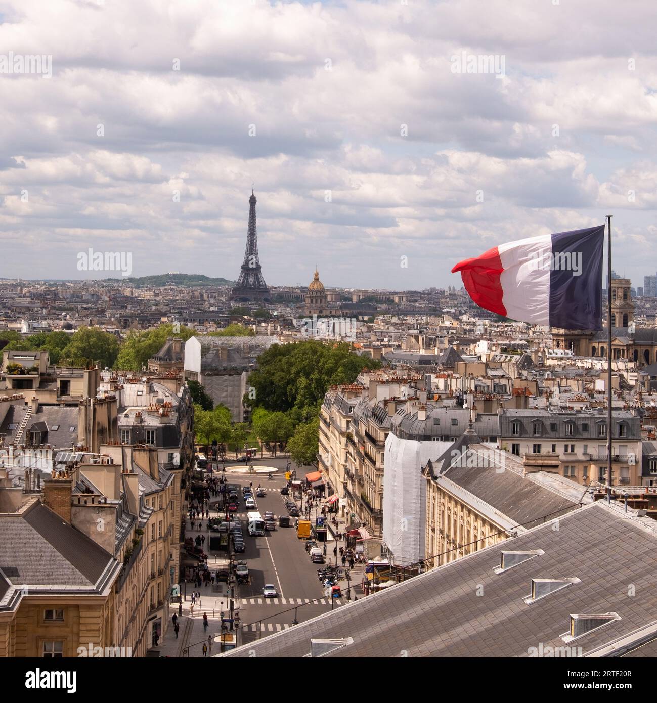 France, Paris, French flag on building roof, Eiffel tower in background ...