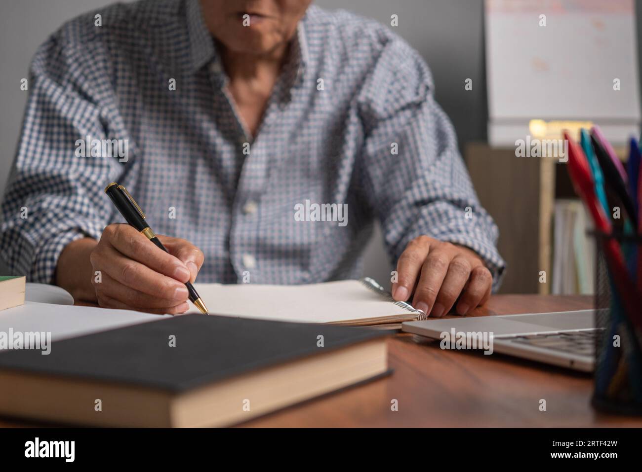 Asian senior businessman taking notes on business report Stock Photo ...