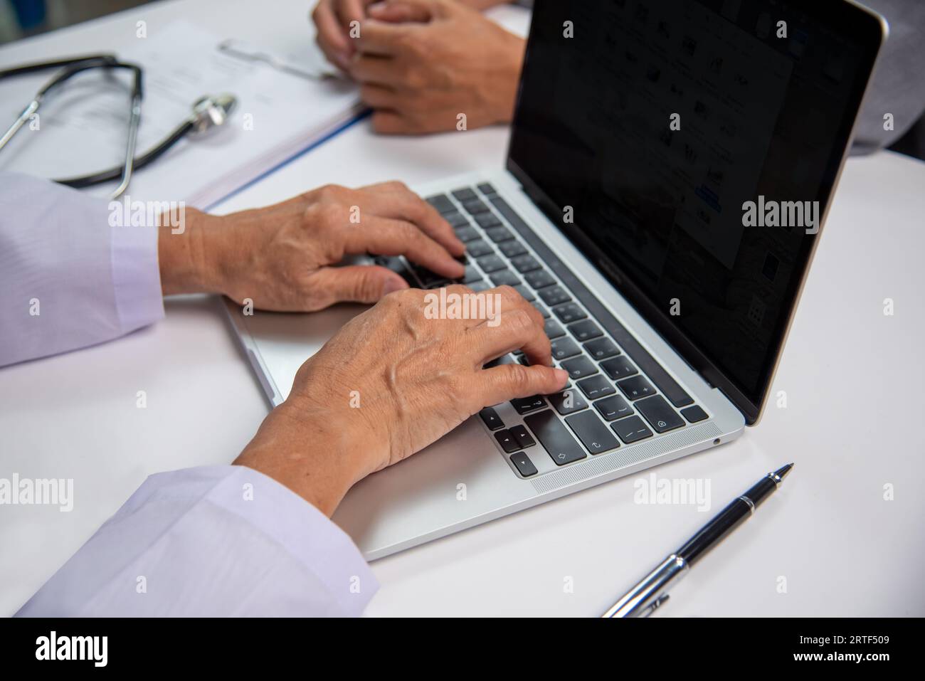 Female doctor using computer to look at patient report and history ...