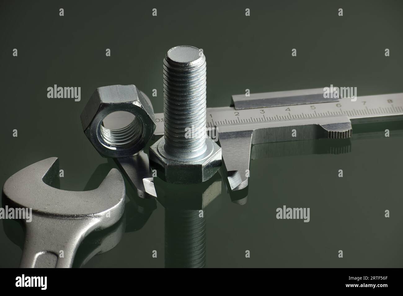 Close-up view of a mechanical setup involving a wrench and caliper, nut ...