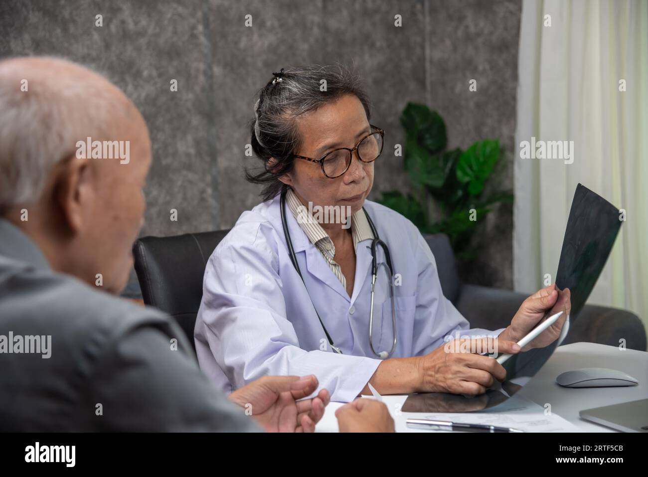 Asian woman doctor watching patient x-ray film, MRI and CT scan. Health ...