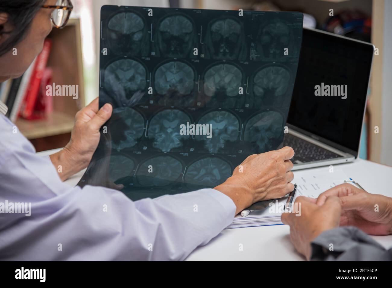Asian woman doctor watching patient x-ray film, MRI and CT scan. Health ...