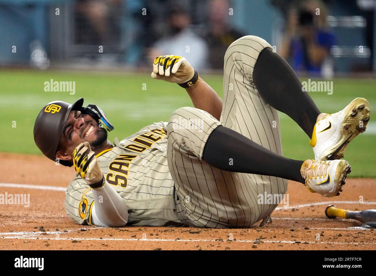 San Diego Padres' Xander Bogaerts writhes on the ground after being hit ...