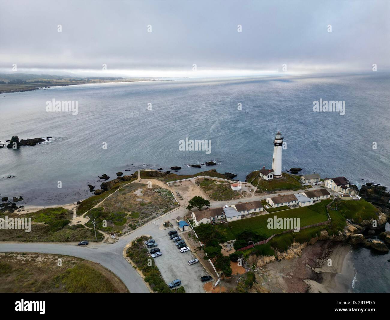 A scenic view of a lighthouse perched on a grassy hilltop overlooking ...