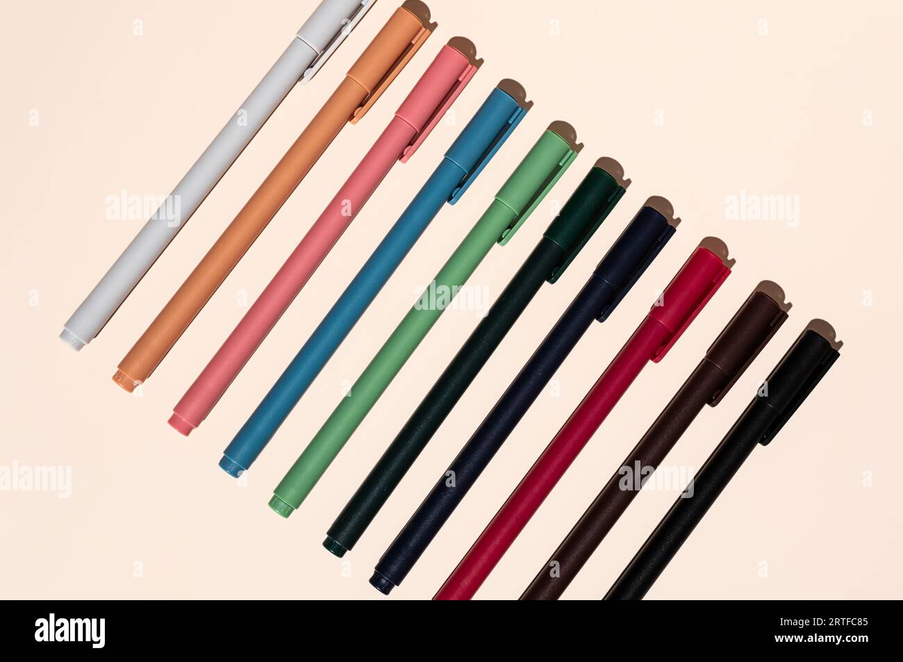 Some colourful pen arranging on beige Stock Photo - Alamy