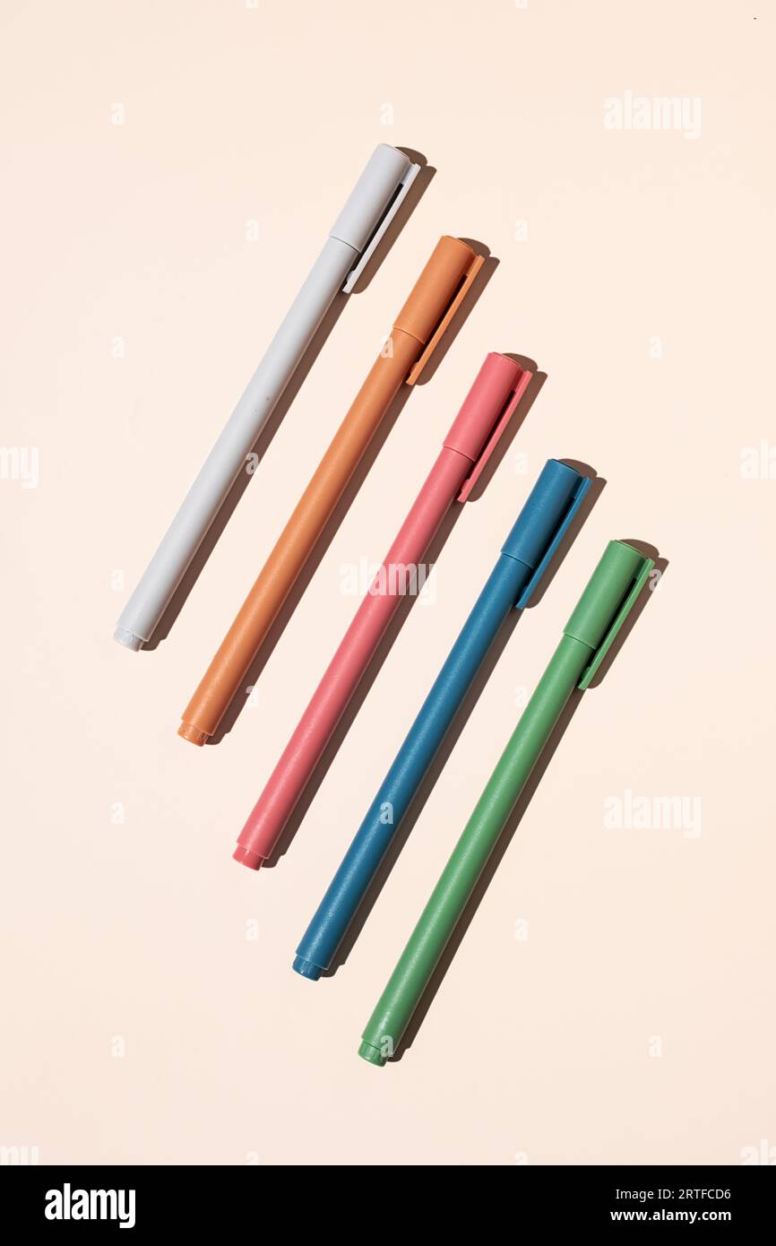 Some colourful pen arranging on beige Stock Photo - Alamy