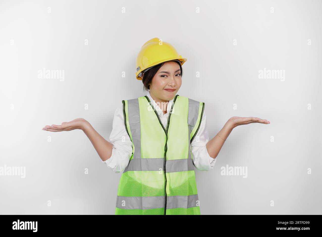 A thoughtful young woman labor wearing safety helmet and vest is ...